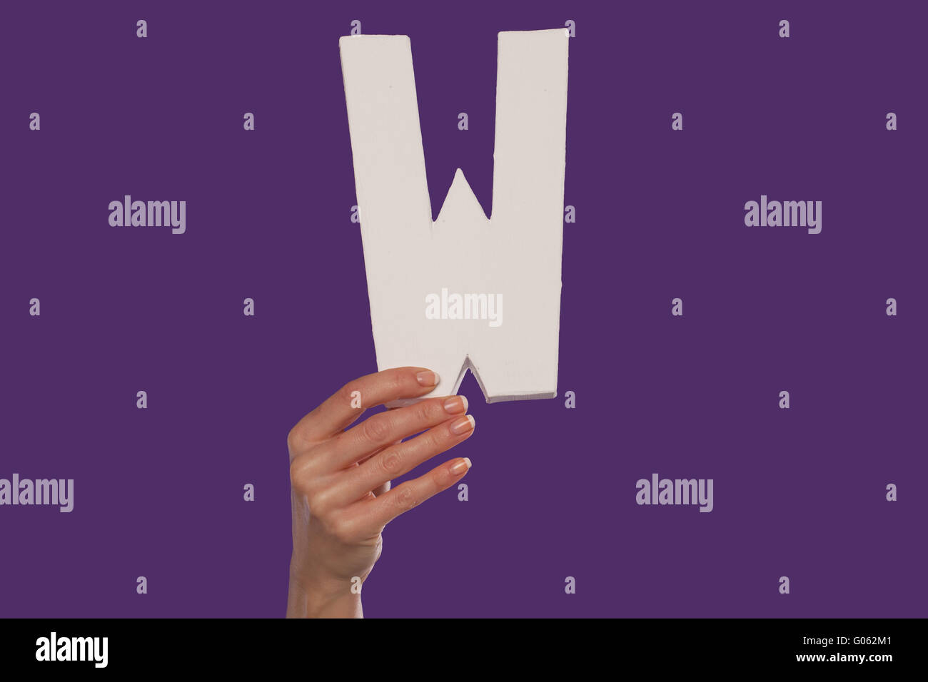 female hand holding a letter W from the bottom Stock Photo - Alamy