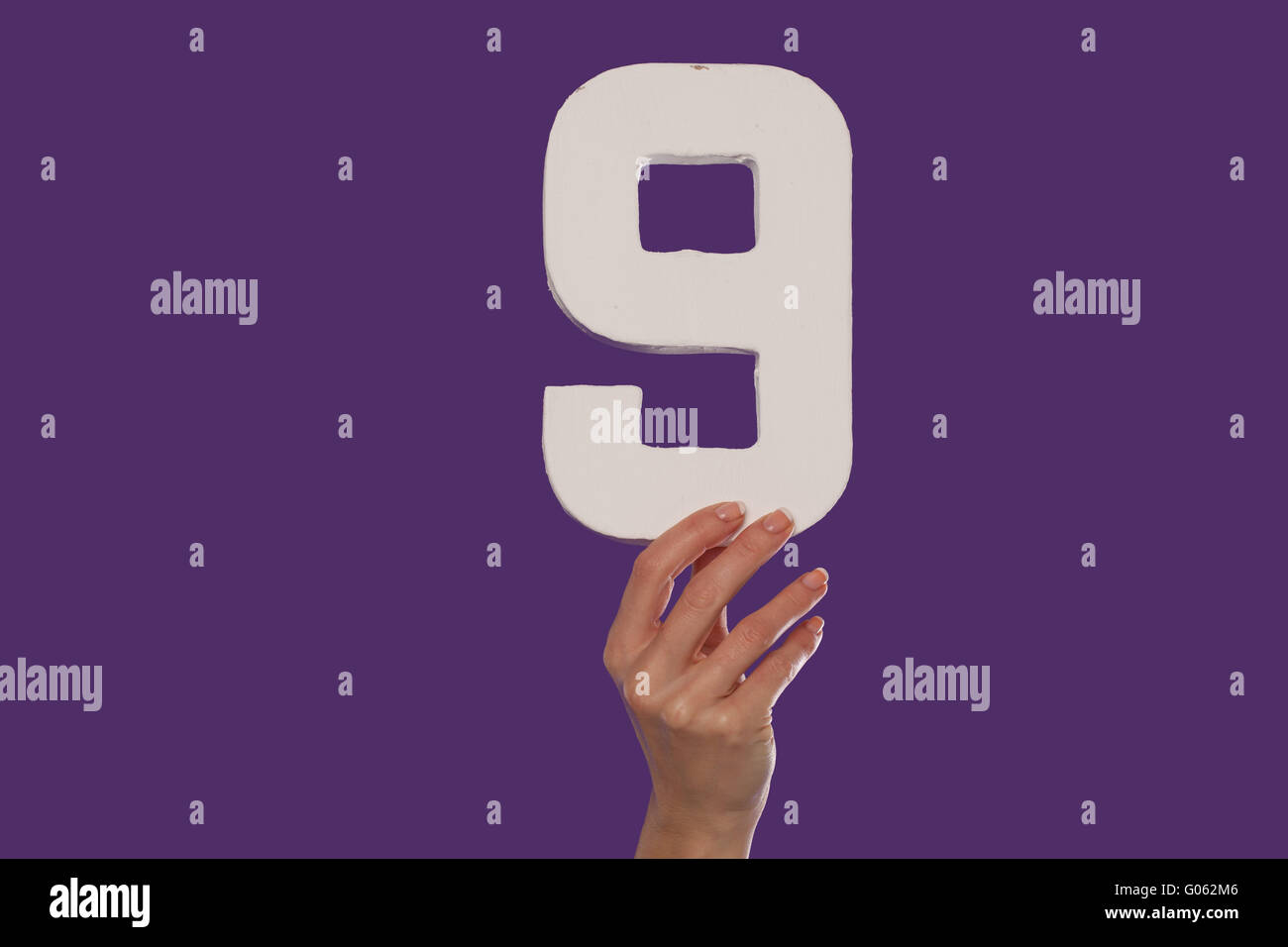 Female hand holding up the number 9 from the top Stock Photo - Alamy