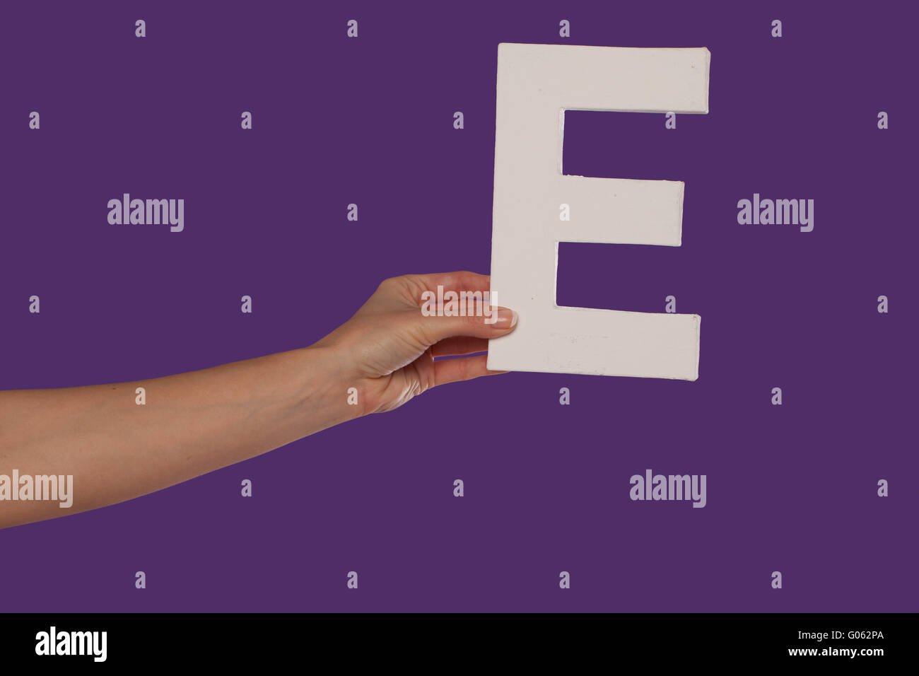 Female hand holding up the letter E from the left Stock Photo - Alamy