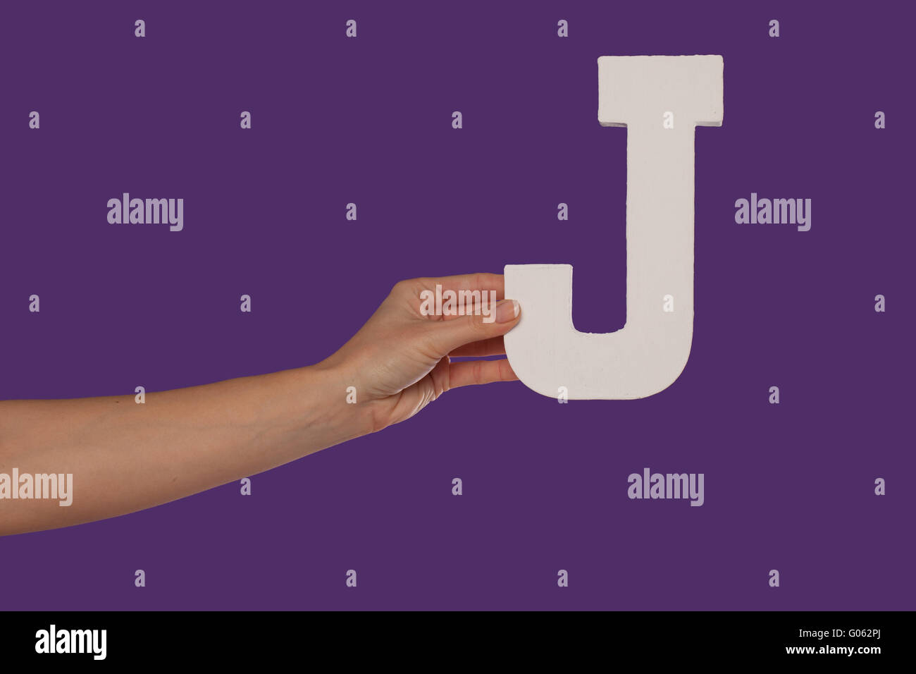 Female hand holding up the letter J from the left Stock Photo - Alamy