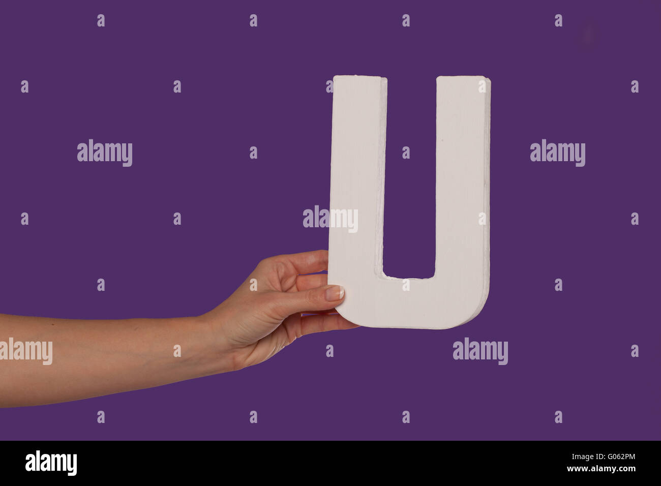 Female hand holding up the letter U from the left Stock Photo - Alamy