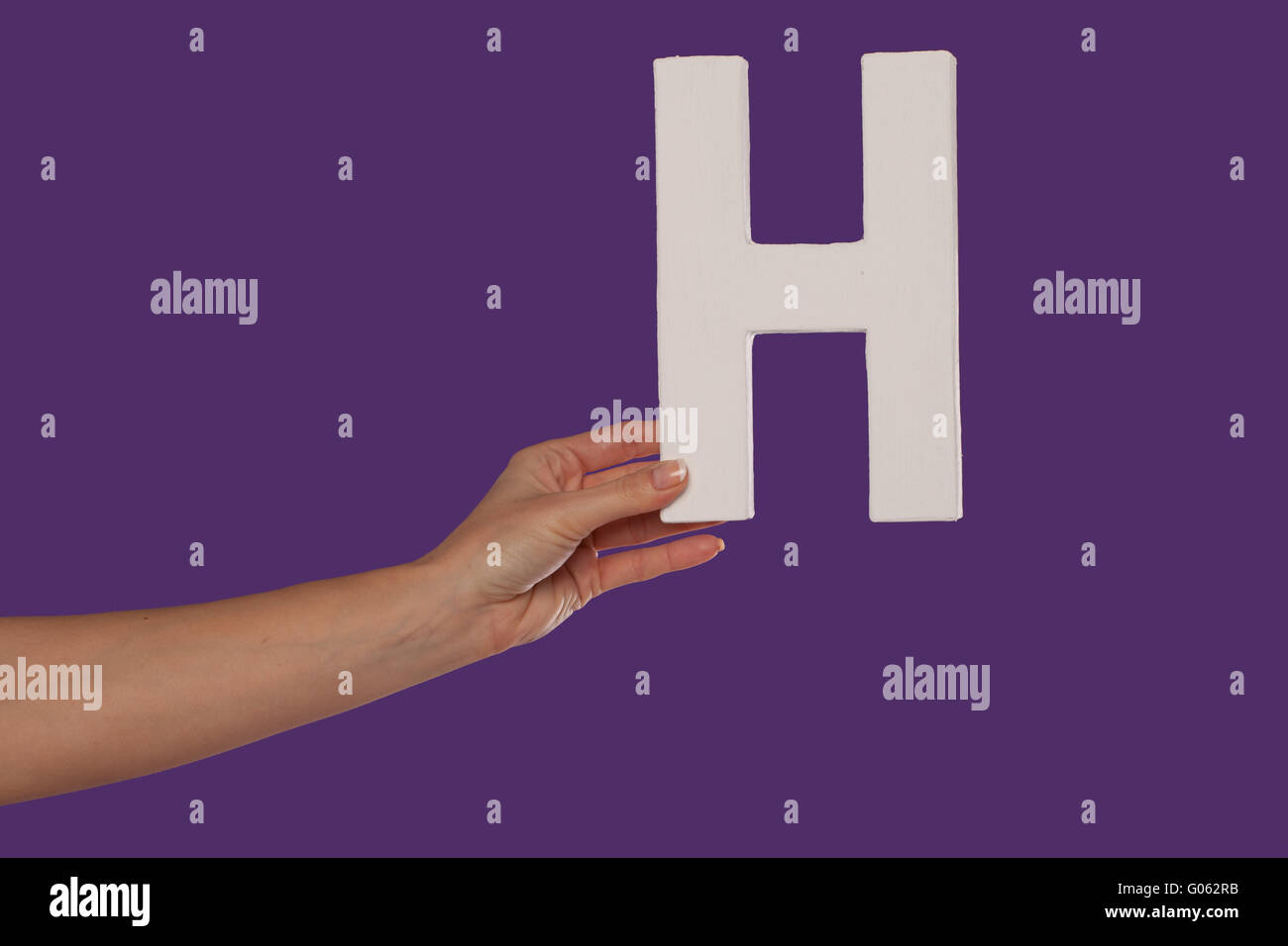 Female hand holding up the letter H from the left Stock Photo - Alamy