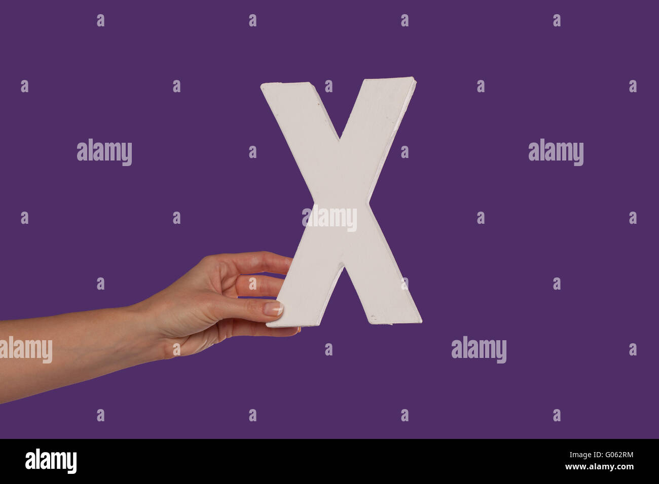 Female hand holding up the letter X from the left Stock Photo - Alamy