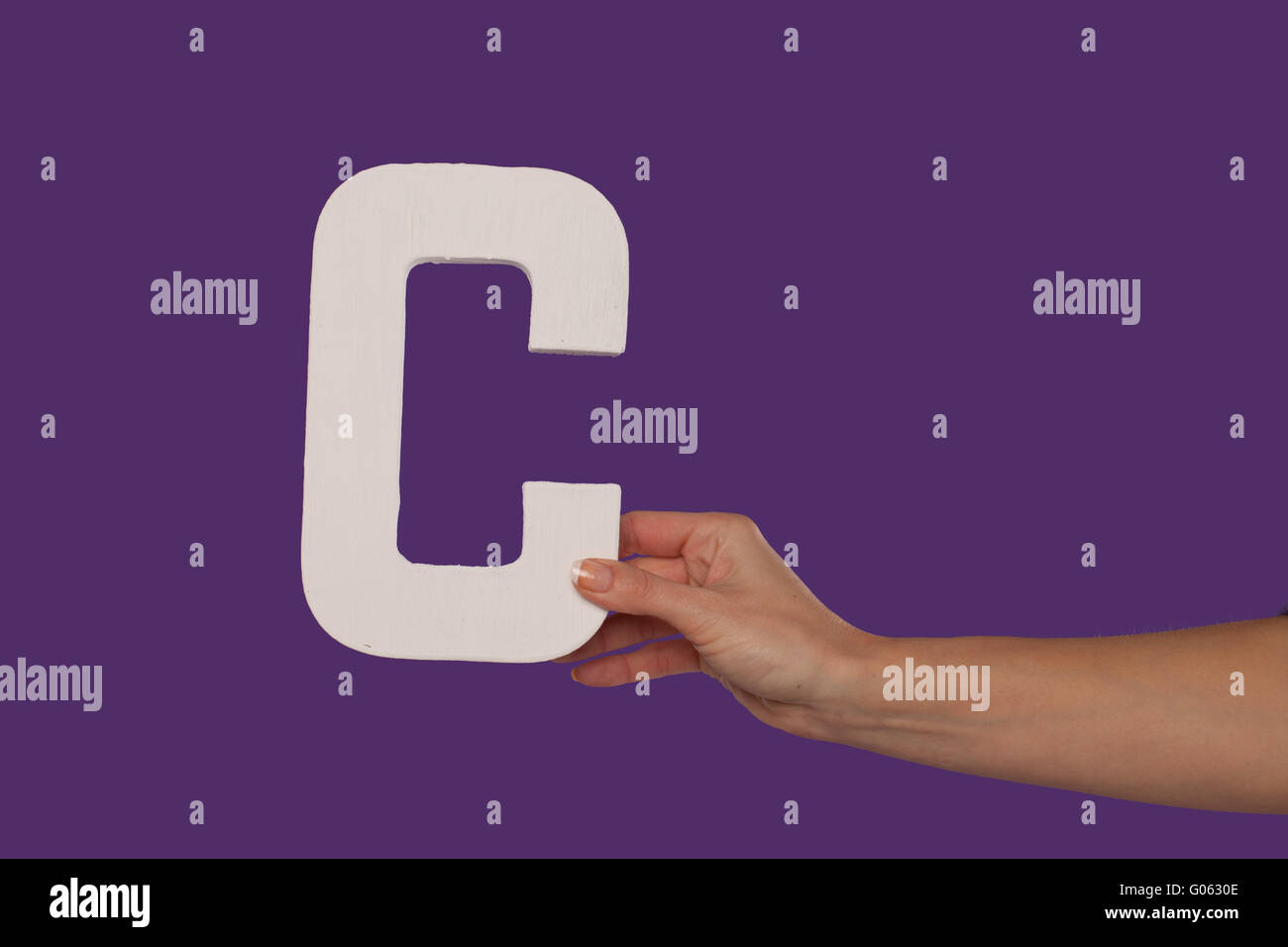 Female hand holding up the letter C from the right Stock Photo - Alamy