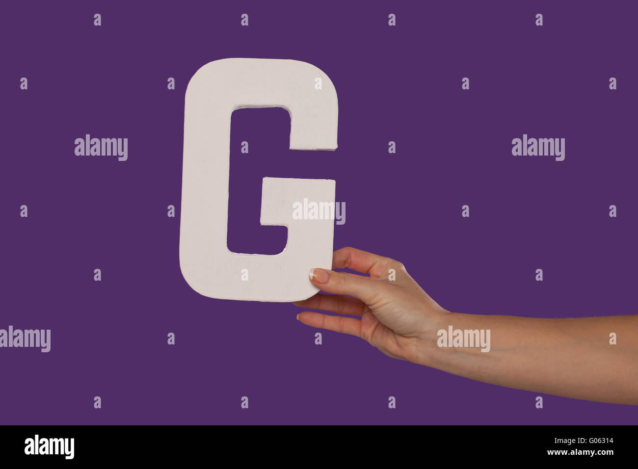 Female hand holding up the letter G from the right Stock Photo - Alamy