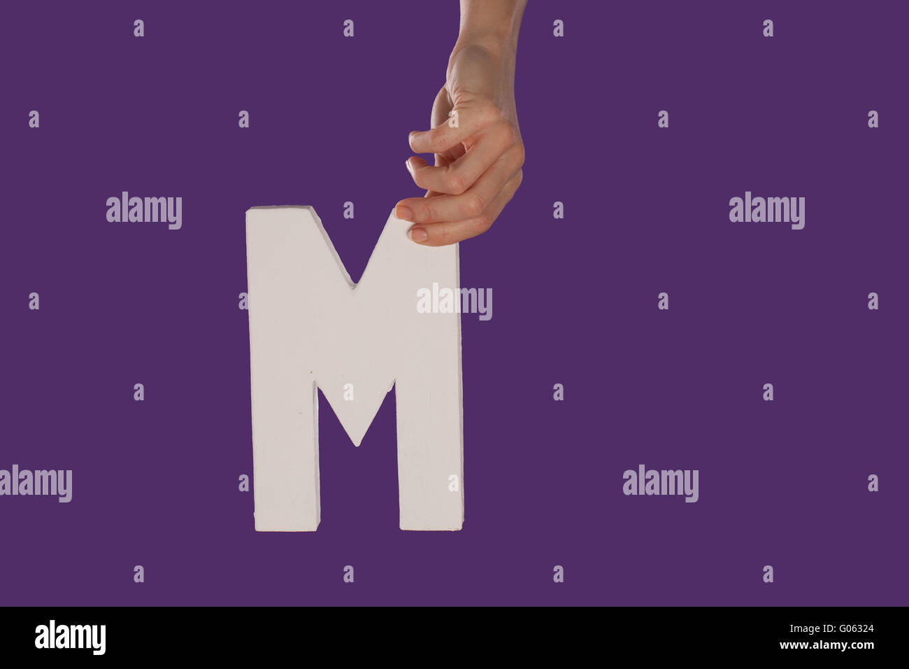 Female hand holding up the letter M from top Stock Photo - Alamy