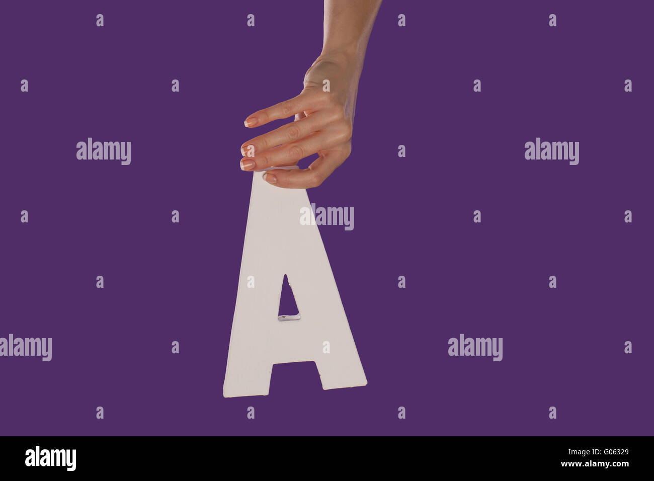 Female hand holding up the letter A from top Stock Photo - Alamy