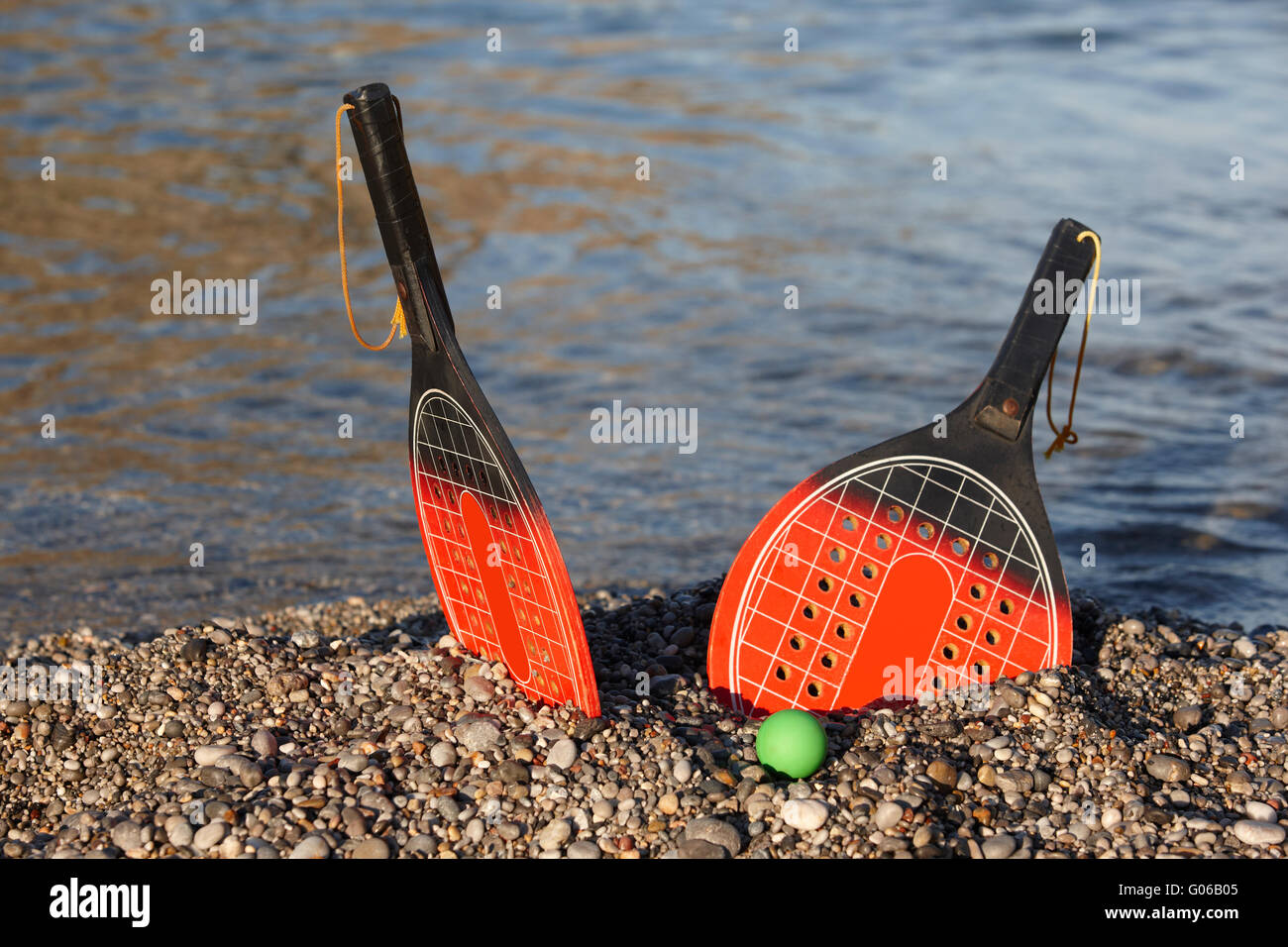Red and black beach bats near the sea shore. Horizontal Stock Photo - Alamy