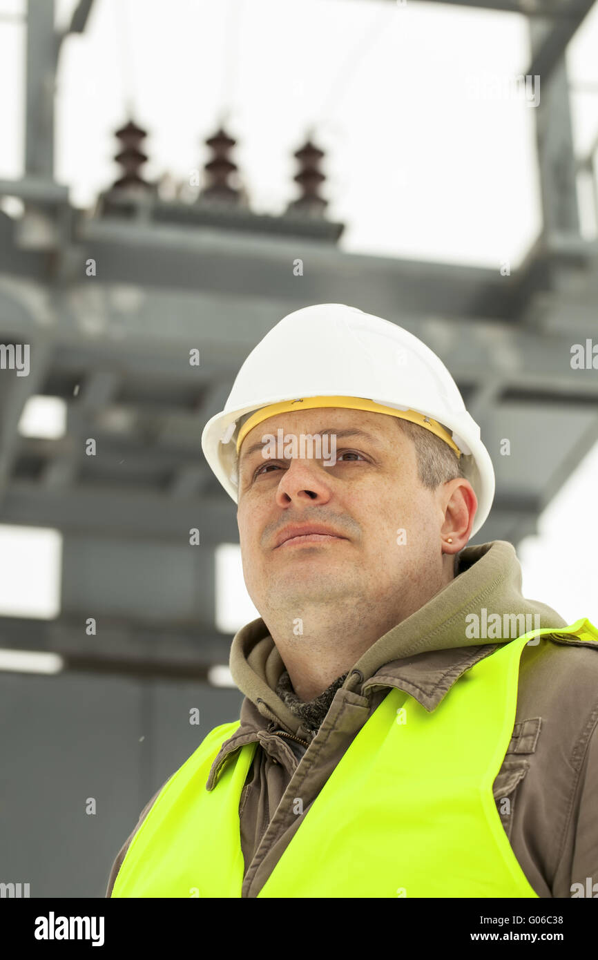 Engineer on a transformer background in winter Stock Photo - Alamy