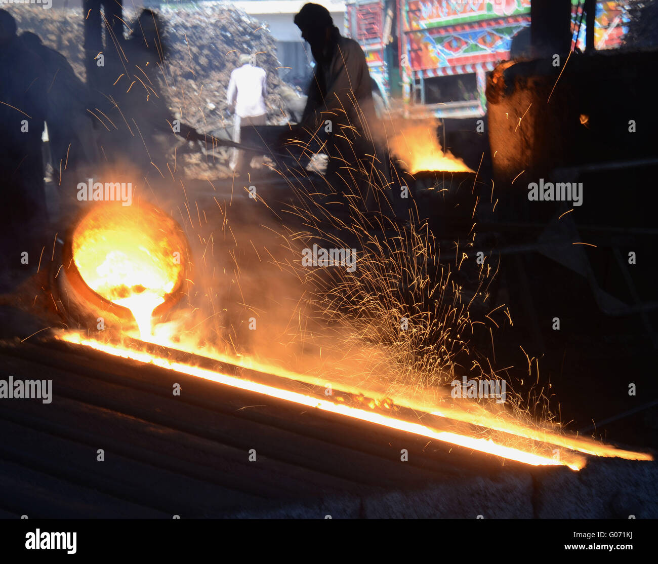 Pakistani blacksmiths work at an iron molding factory in an industrial ...