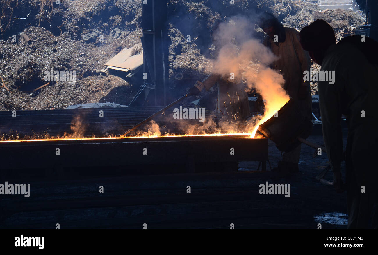 Pakistani blacksmiths work at an iron molding factory in an industrial ...