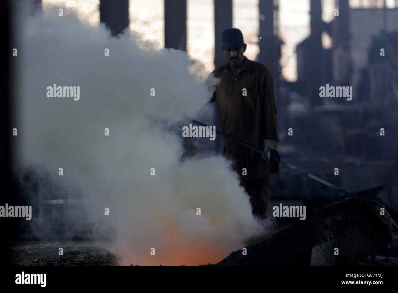 Pakistani blacksmiths work at an iron molding factory in an industrial ...