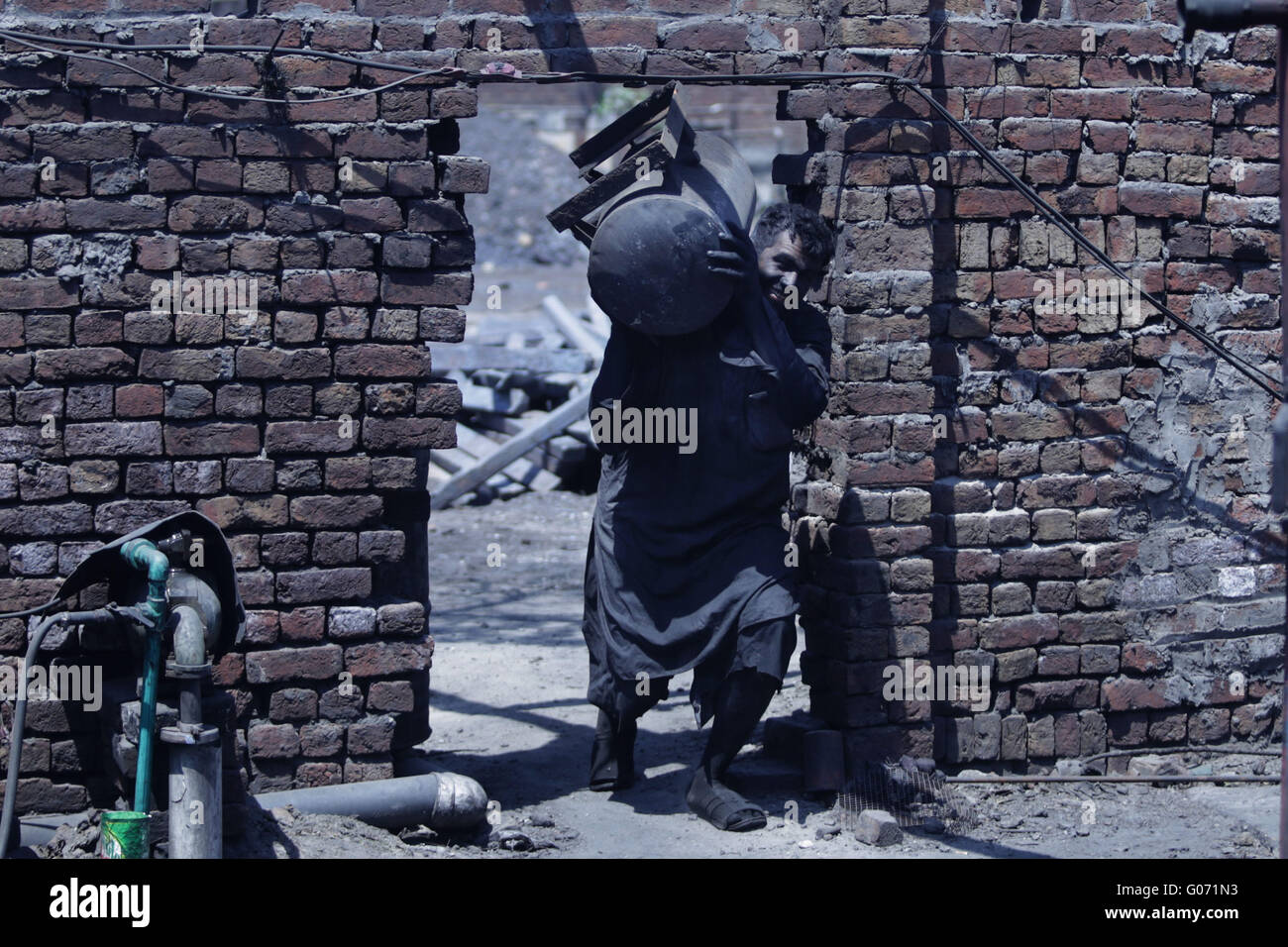 Pakistani blacksmiths work at an iron molding factory in an industrial ...