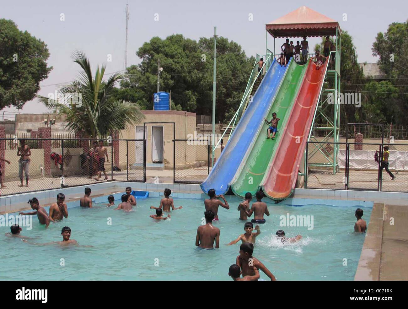 Residents of Karachi enjoying bath in a pool to beat the heat of ...