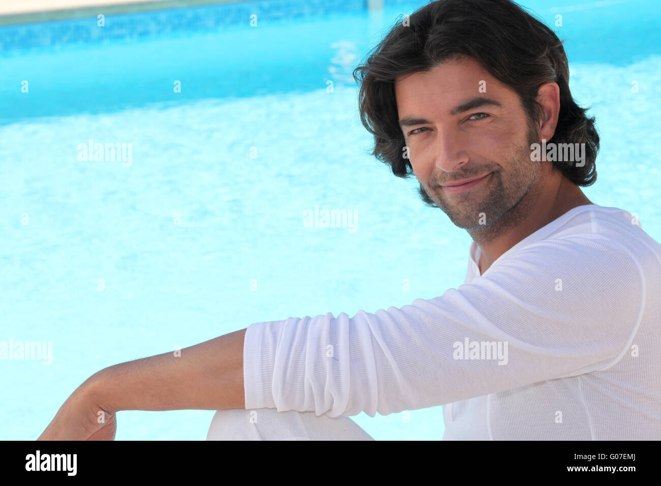Man sat by swimming pool Stock Photo - Alamy