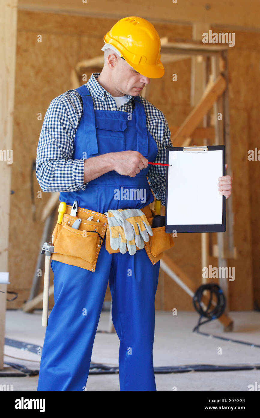 Portrait of foreman pointing at white folder plate Stock Photo - Alamy