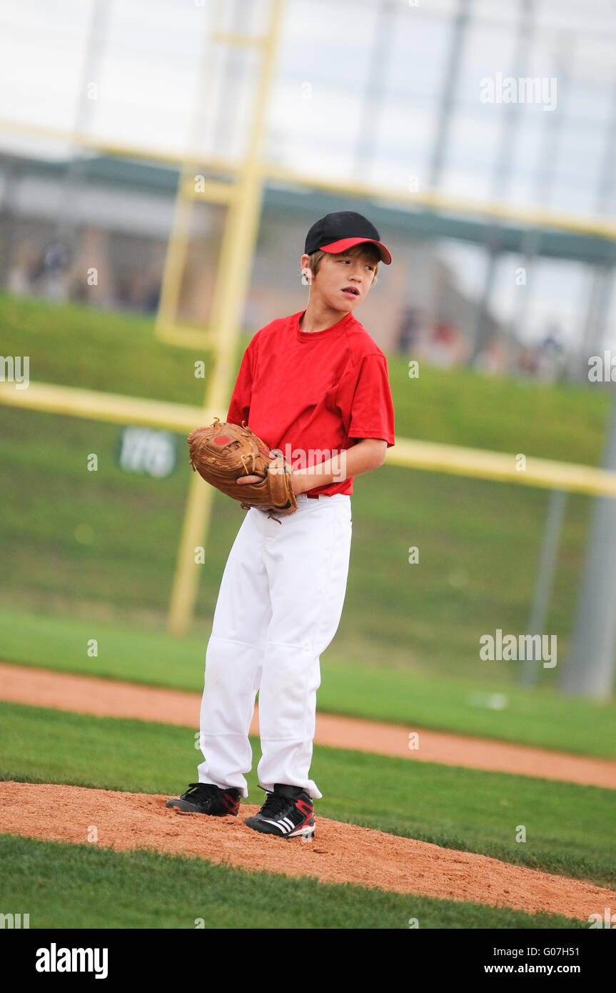 Little league pitcher in red looking Stock Photo - Alamy