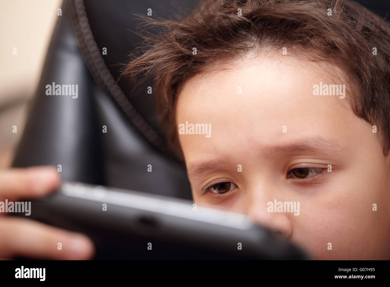 Boy tired of playing his portable game console Stock Photo - Alamy