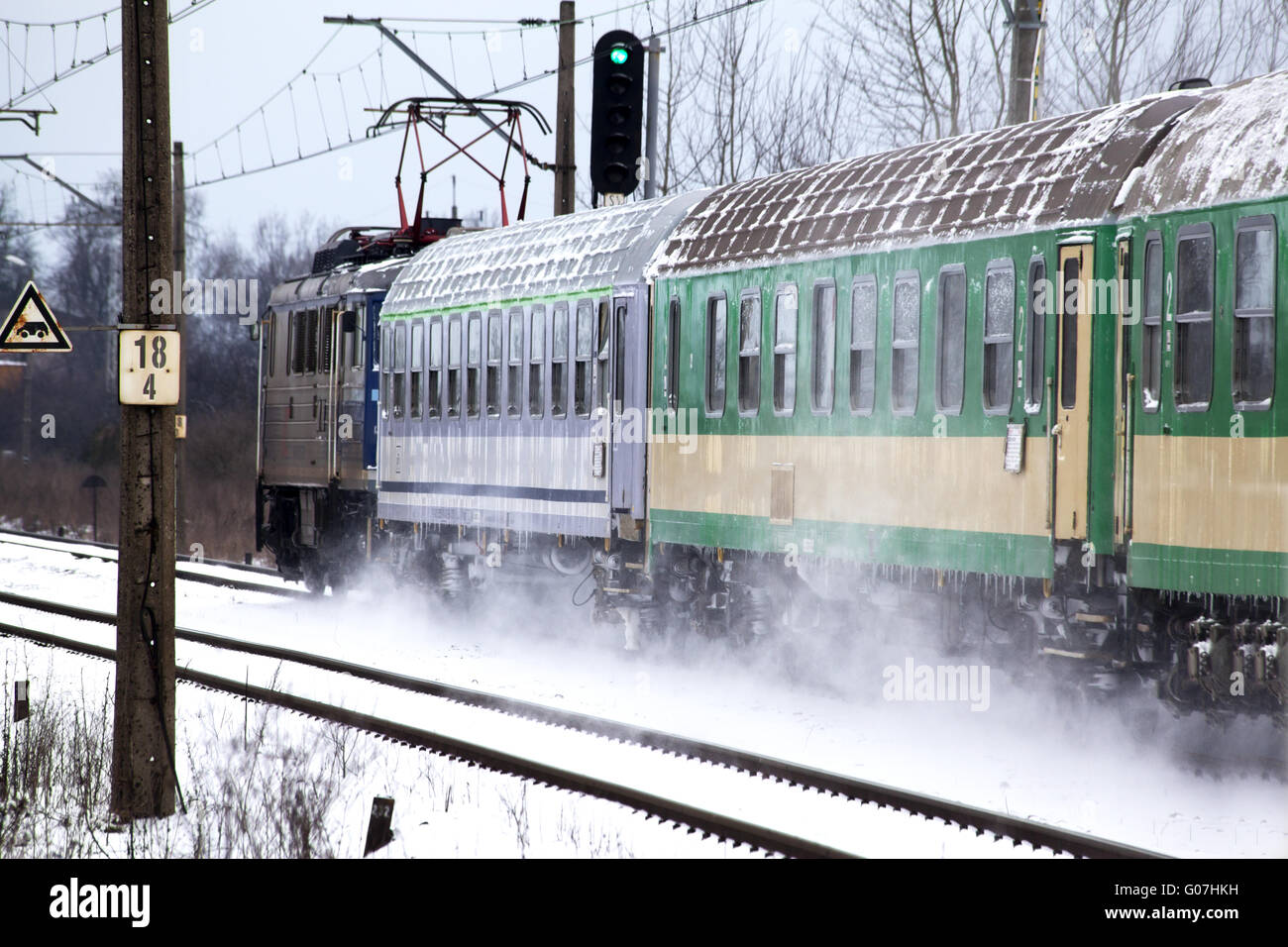Passenger train passes the snowy line during winte Stock Photo - Alamy