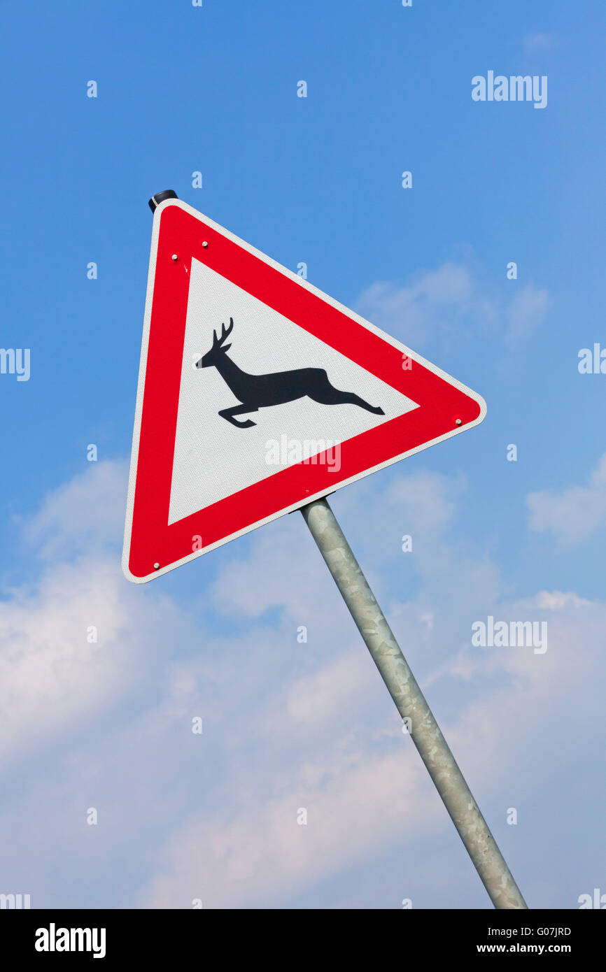 Wildlife warning sign for deer crossing the road against blue sky Stock ...