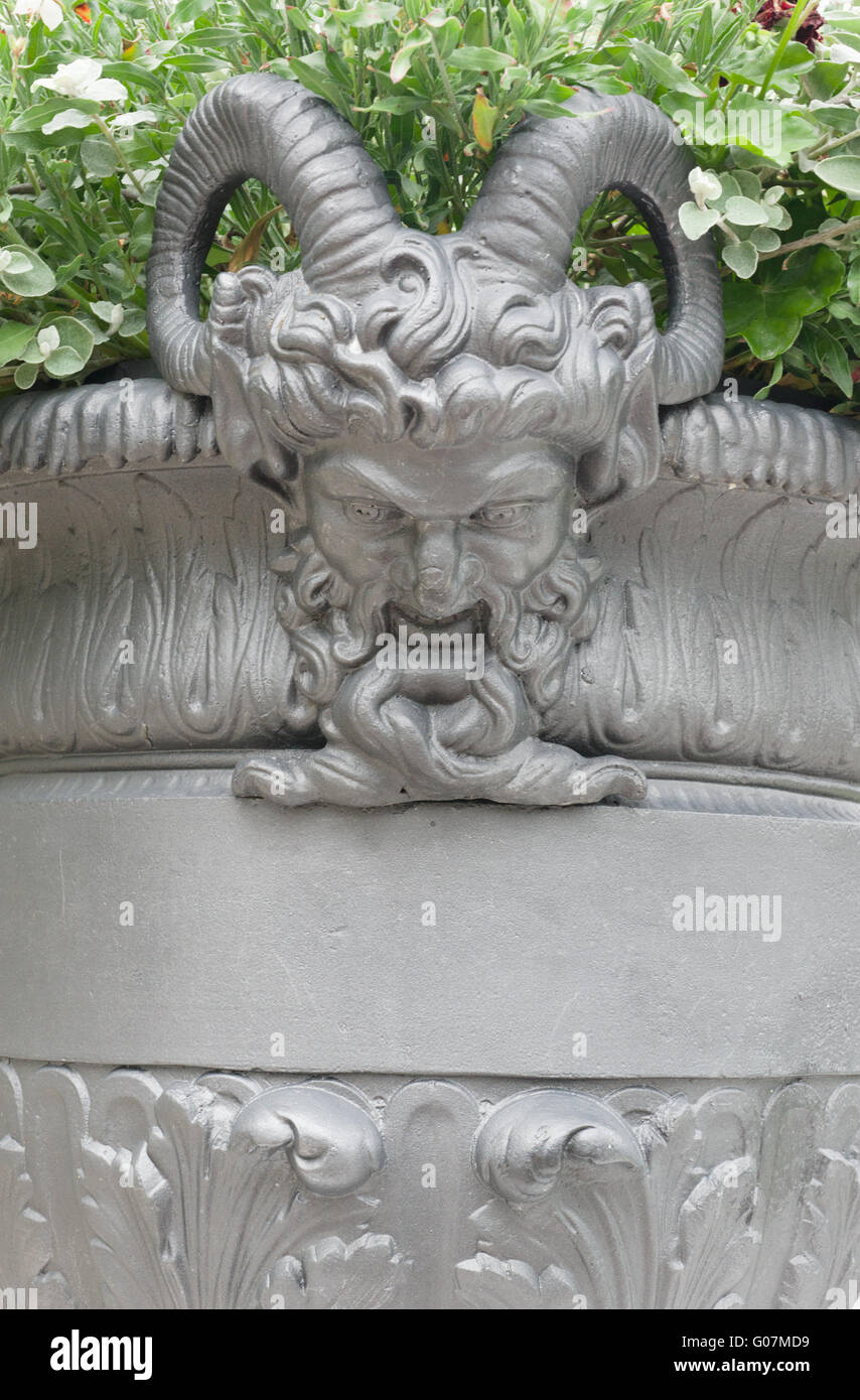 the big flowerpot is decorated with the head of the demon Stock Photo ...