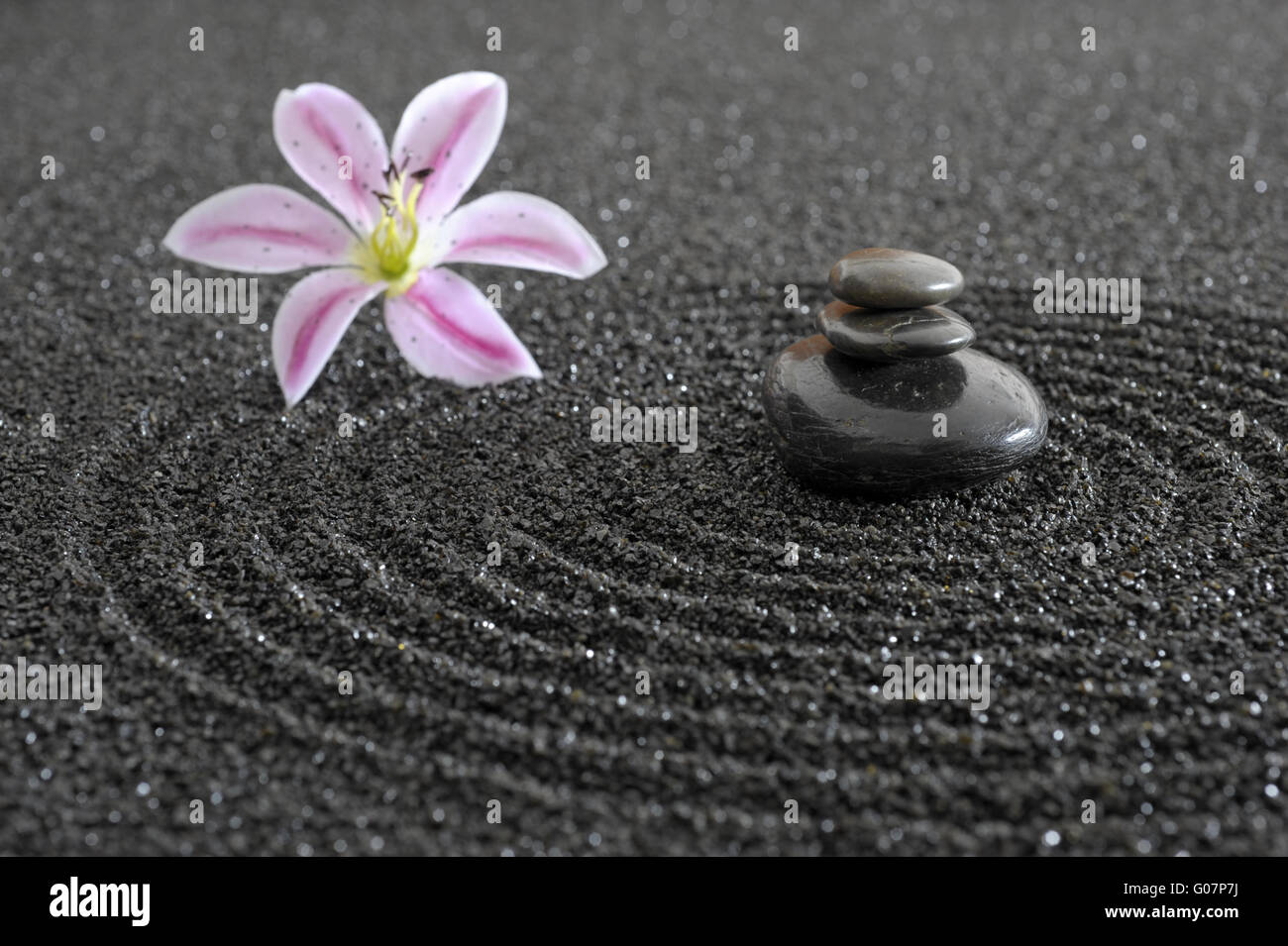 Japan zen garden with stacked stones and flower Stock Photo - Alamy