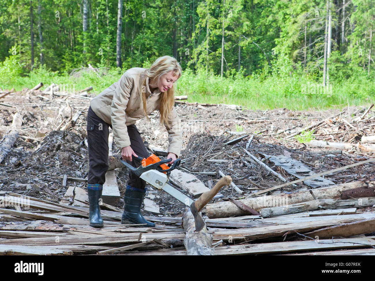 The young woman in wood saws a tree a chain saw Stock Photo - Alamy