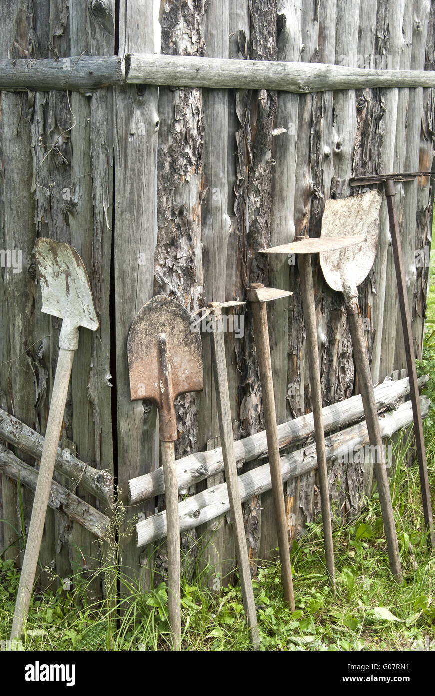 Used farm hand implements on wooden shed wall back Stock Photo - Alamy