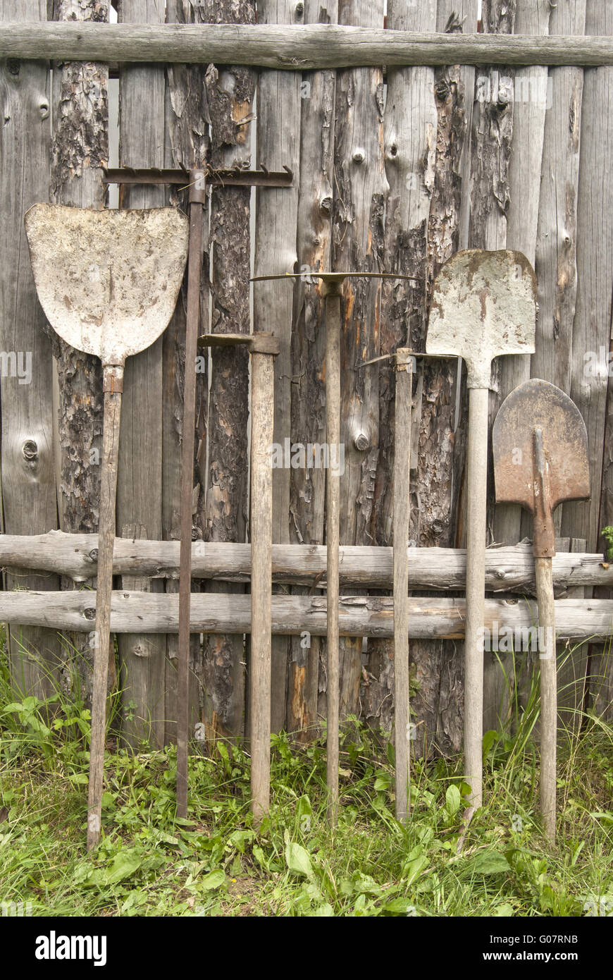 Used farm hand implements on wooden shed wall back Stock Photo - Alamy