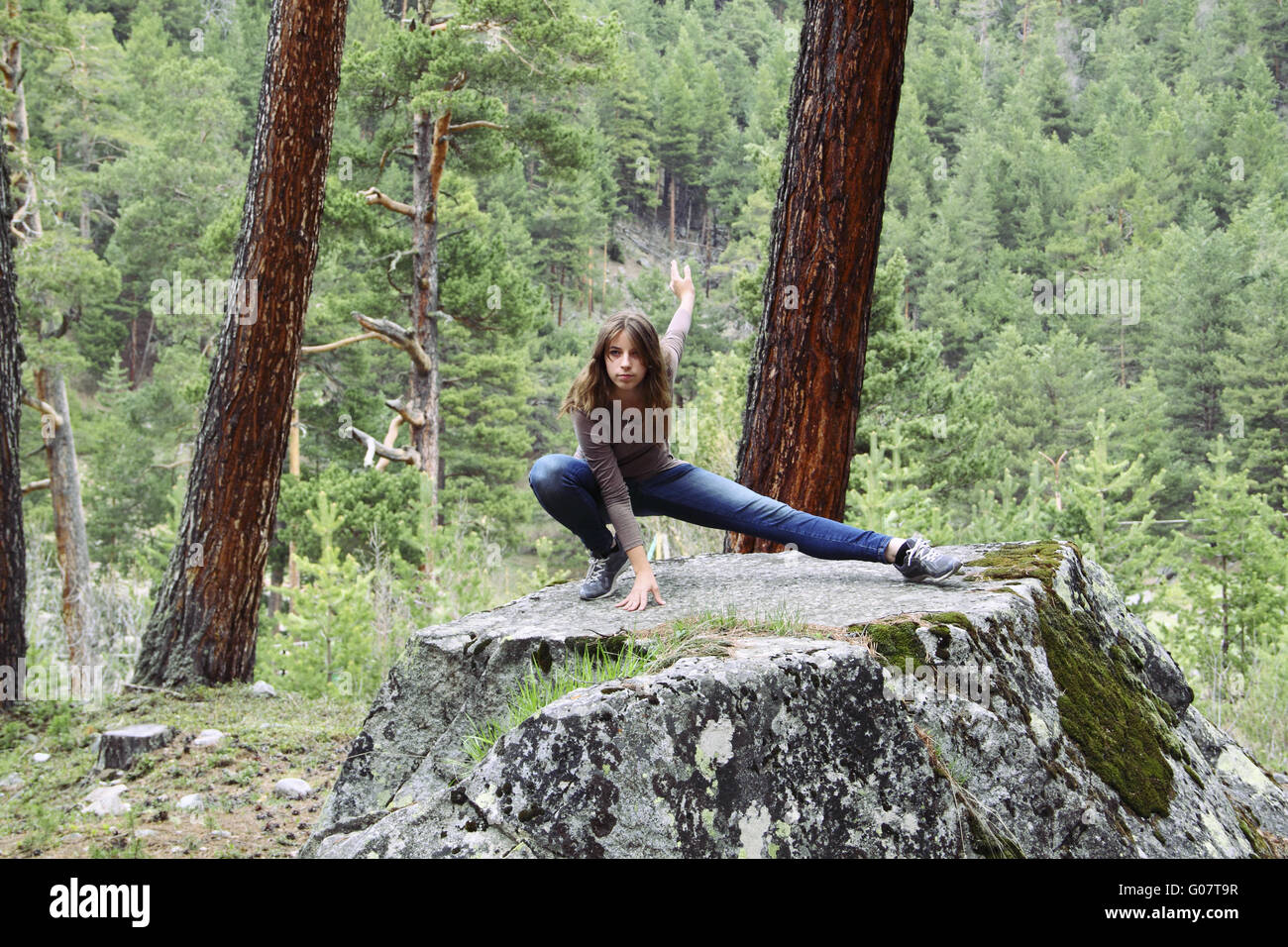 The girl on a large stone doing exercises Stock Photo - Alamy