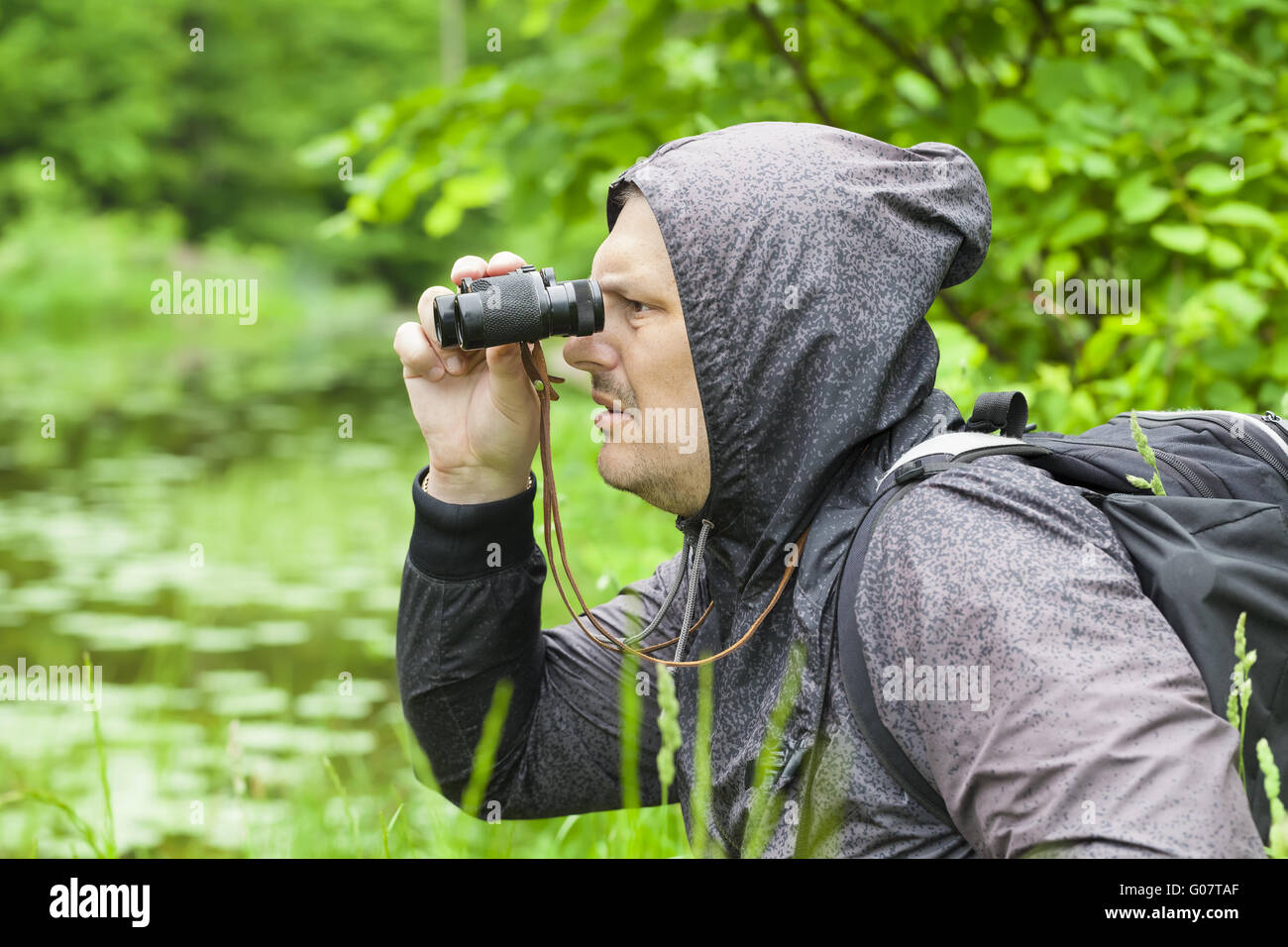 Man with binoculars watching birds at the lake Stock Photo - Alamy