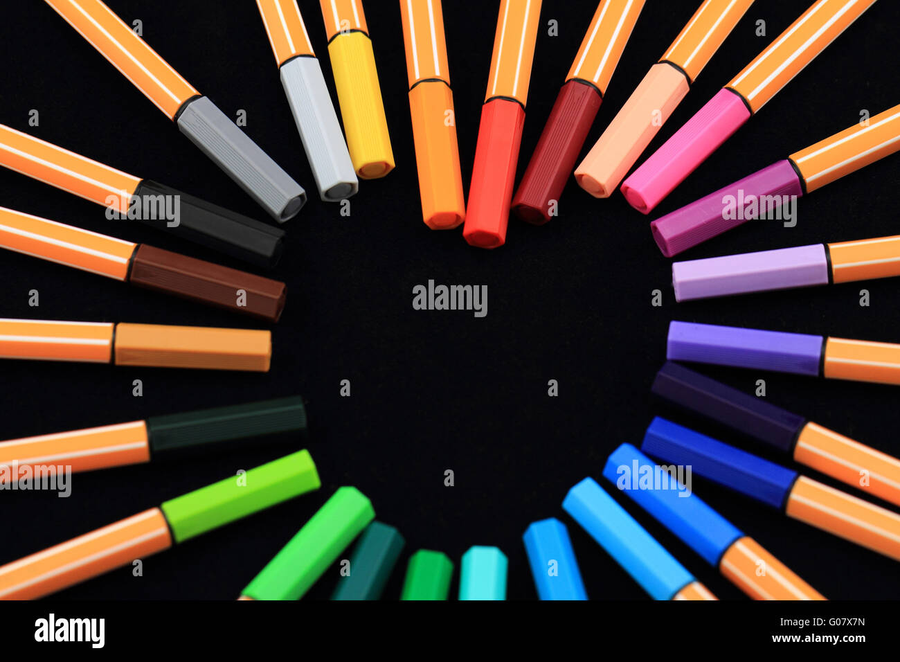 Color Pens in form of love on black background Stock Photo - Alamy
