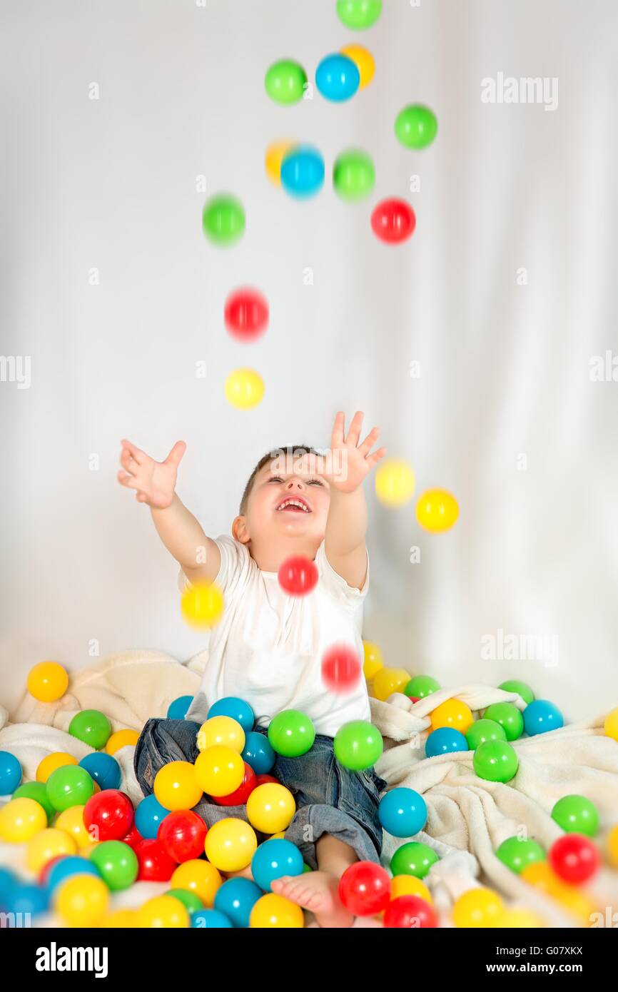 Happy little boy playing with a ball falling Stock Photo - Alamy