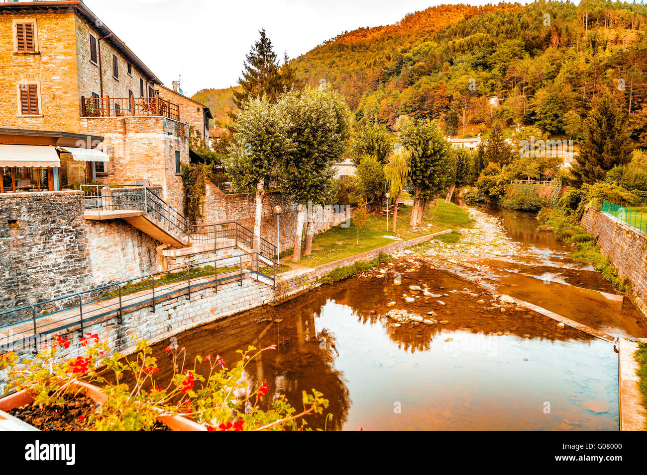 River runs thorugh medieval mountain village in Tuscany characterized ...