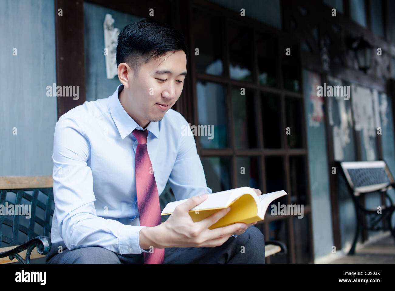 Asian Man Reading a Book Sitting on Bench Stock Photo - Alamy