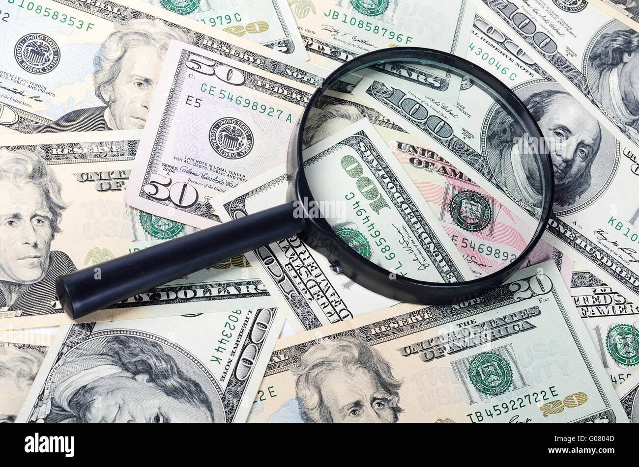 The magnifying glass lying on banknotes closeup Stock Photo - Alamy