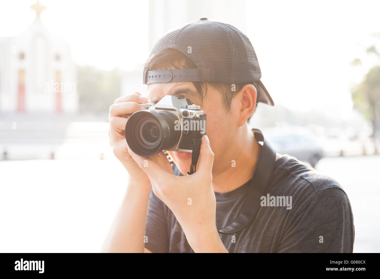Portrait of young photographer shooting photo with camera in summer ...