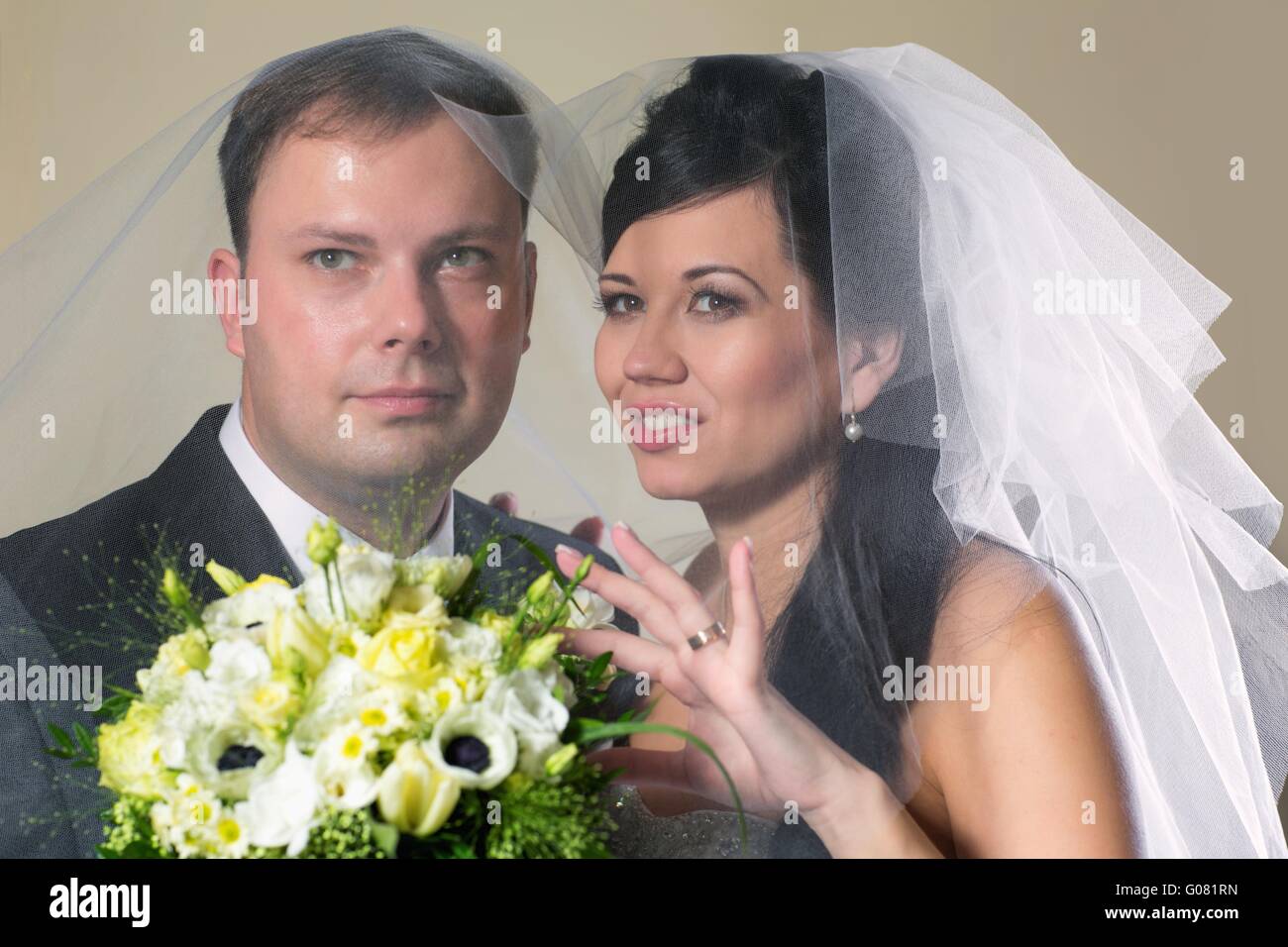 Young bride and groom young together under the wedding veil Stock Photo ...