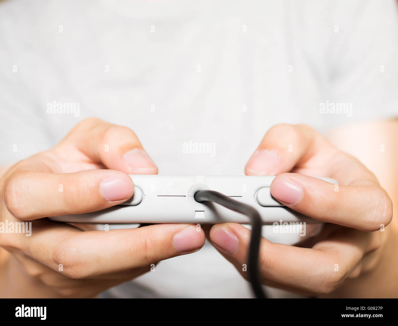 A young man holding game controller playing video games Stock Photo - Alamy