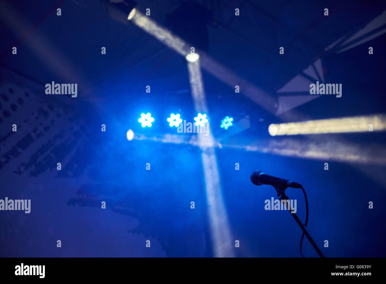 Microphone on stage with blue lights and fog Stock Photo - Alamy