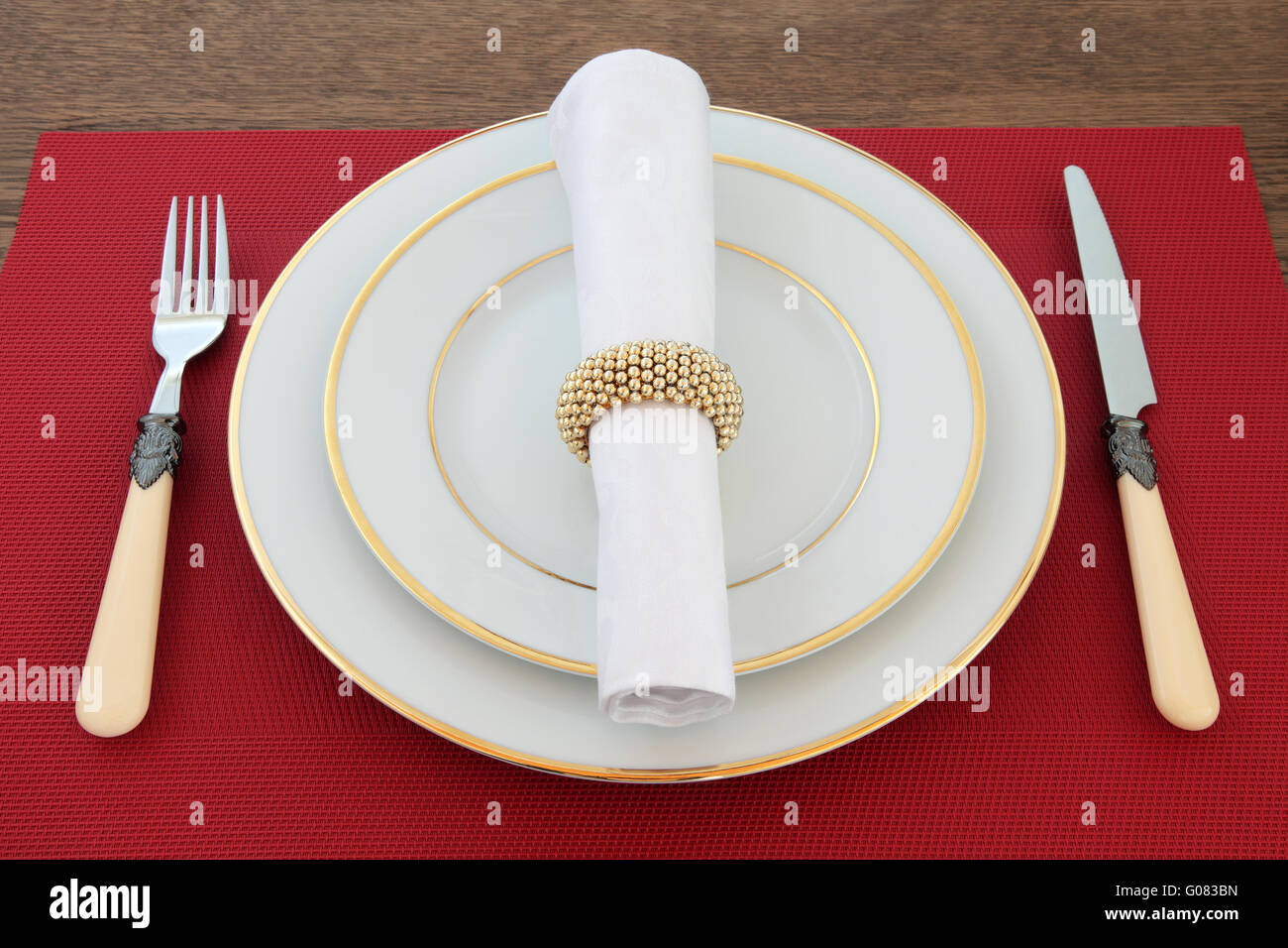 Elegant table setting with white gold rimmed porcelain plates, antique ...