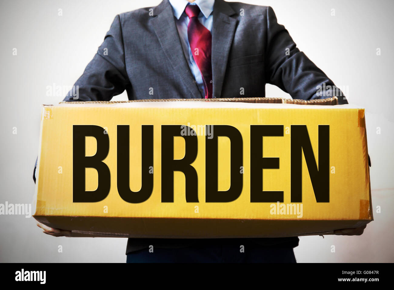 Business man carrying an old box saying "BURDEN" - indicates debt and ...