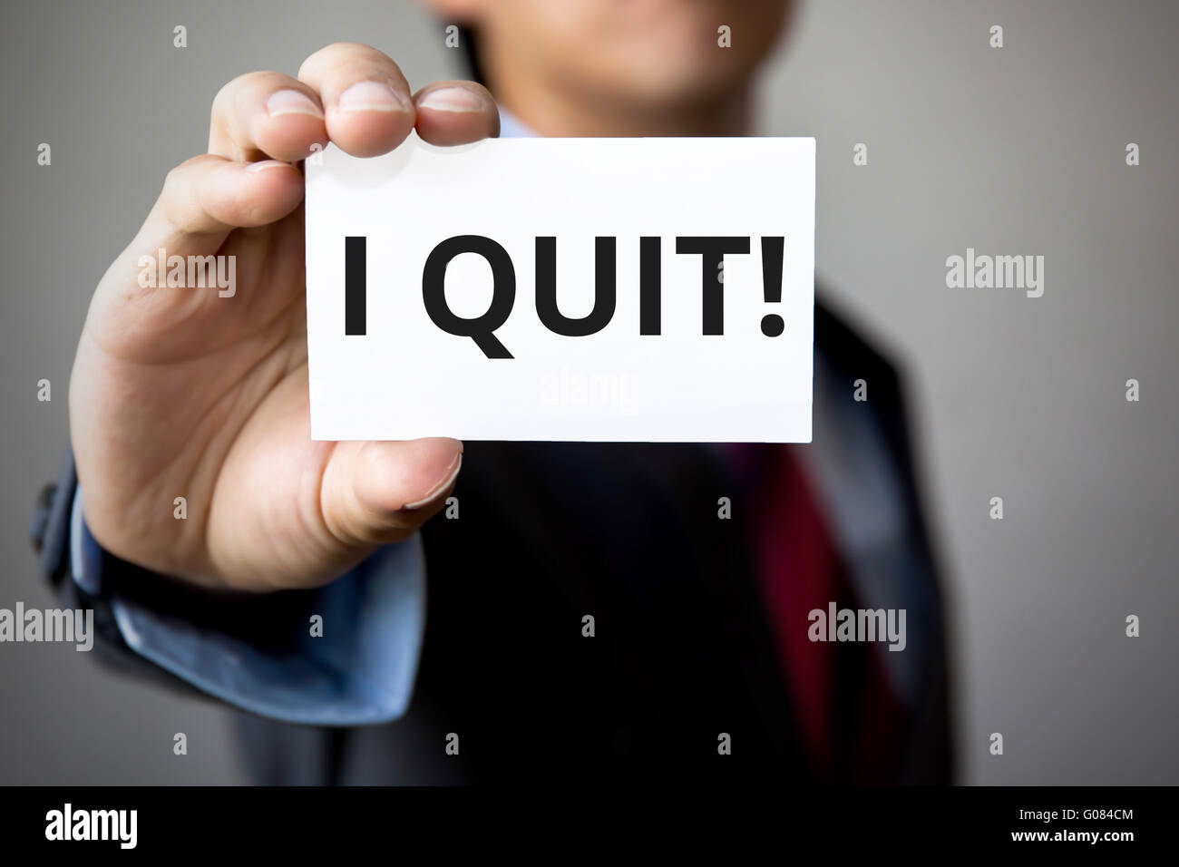 Businessman presenting 'I Quit' word on white card Stock Photo - Alamy