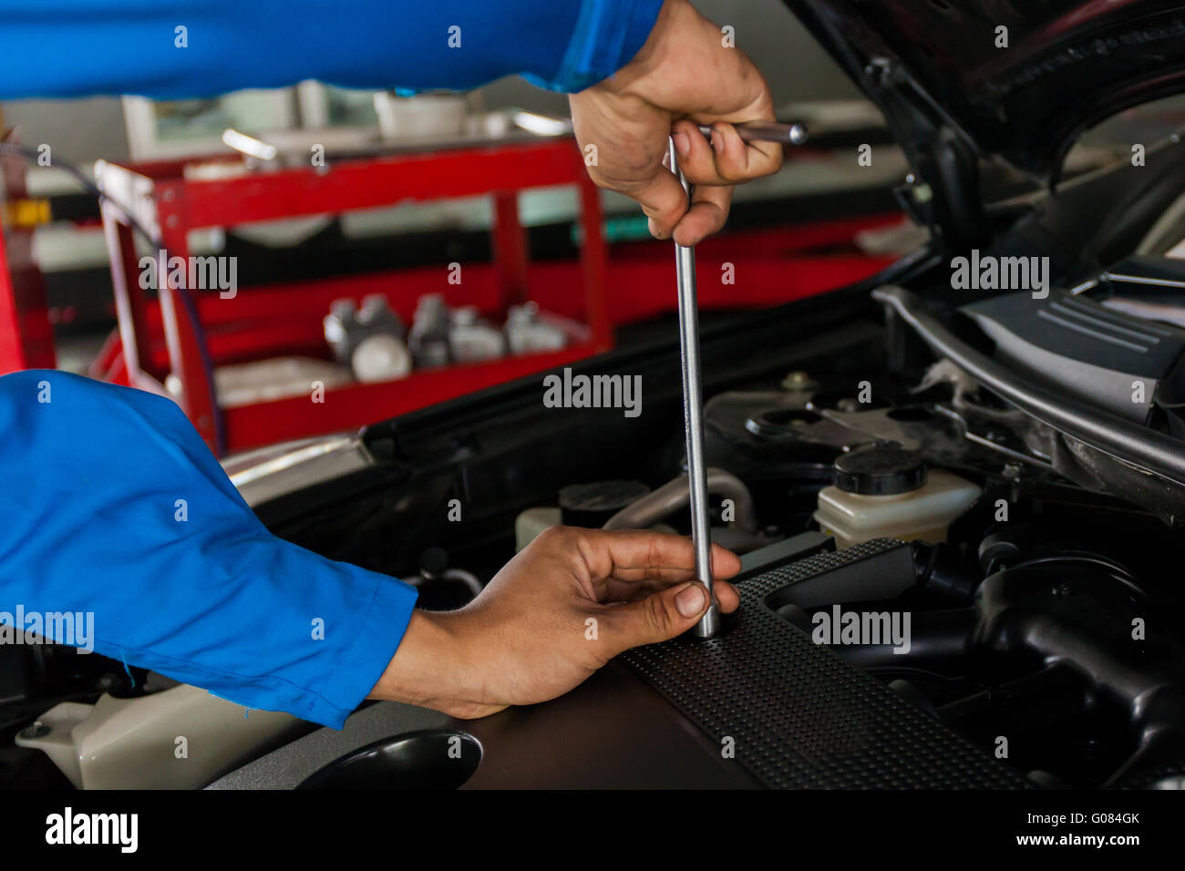 Mechanic checking and fixing a broken car in car service garage with ...