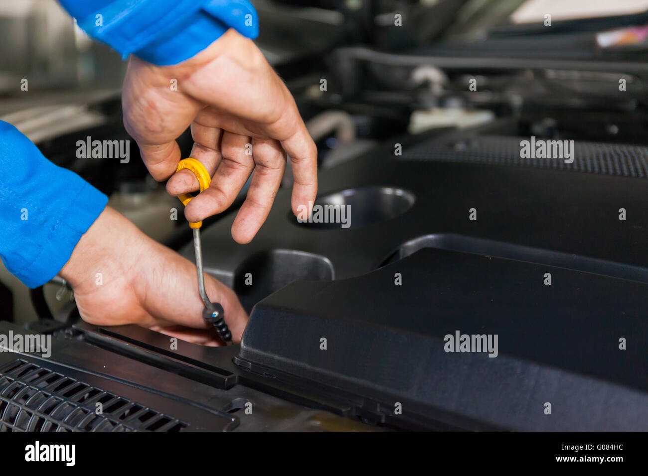 Mechanic checking car's oil level in a car service garage Stock Photo - Alamy