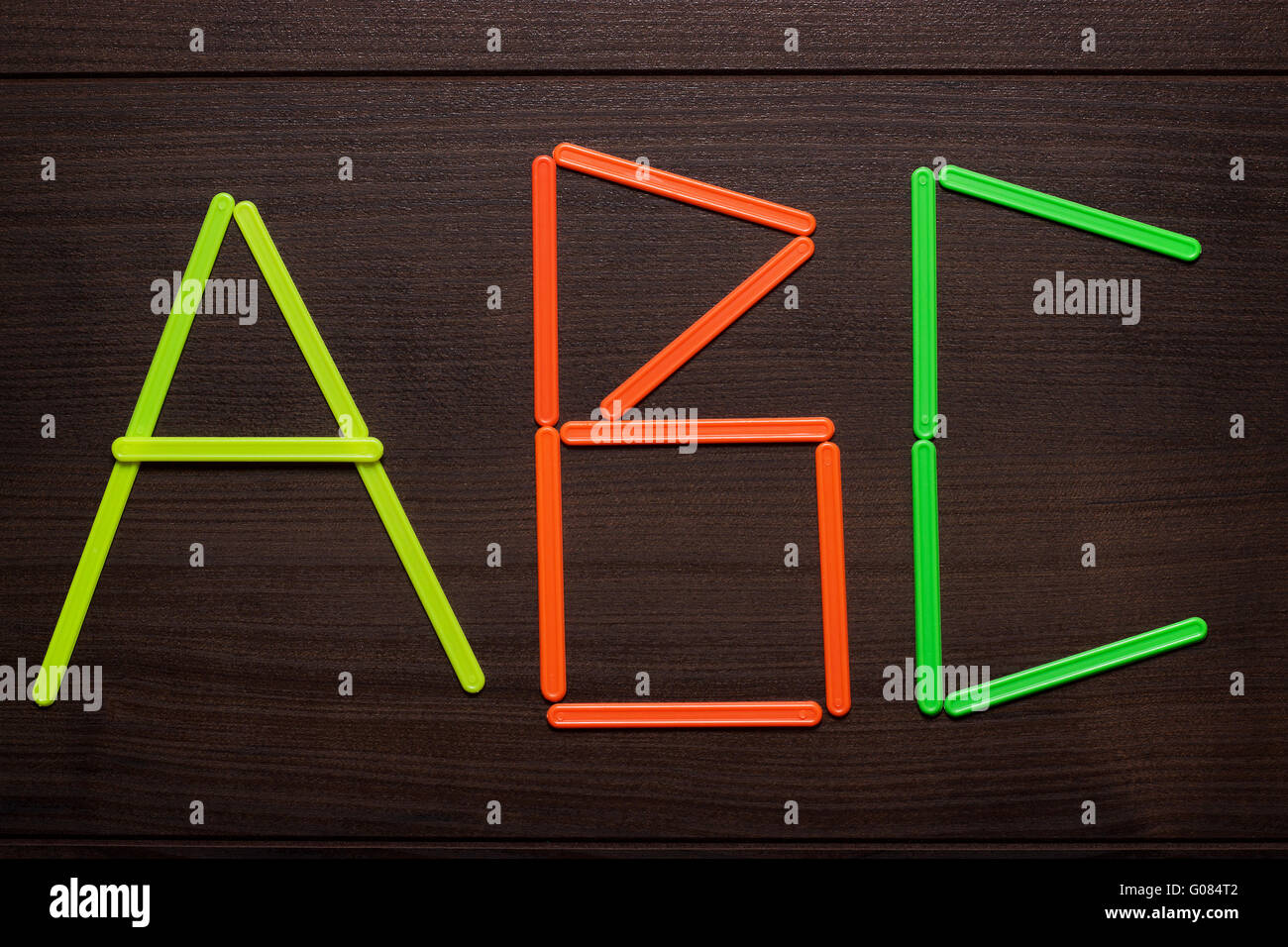 abc formed with counting sticks over wooden backgr Stock Photo - Alamy