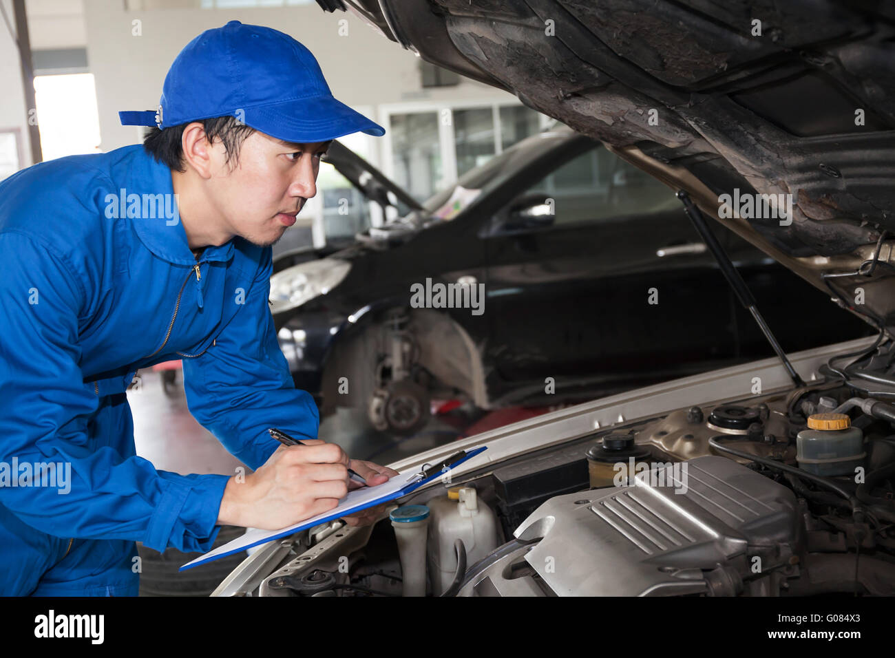 Man in blue technician uniform going to repair for car maintenance ...