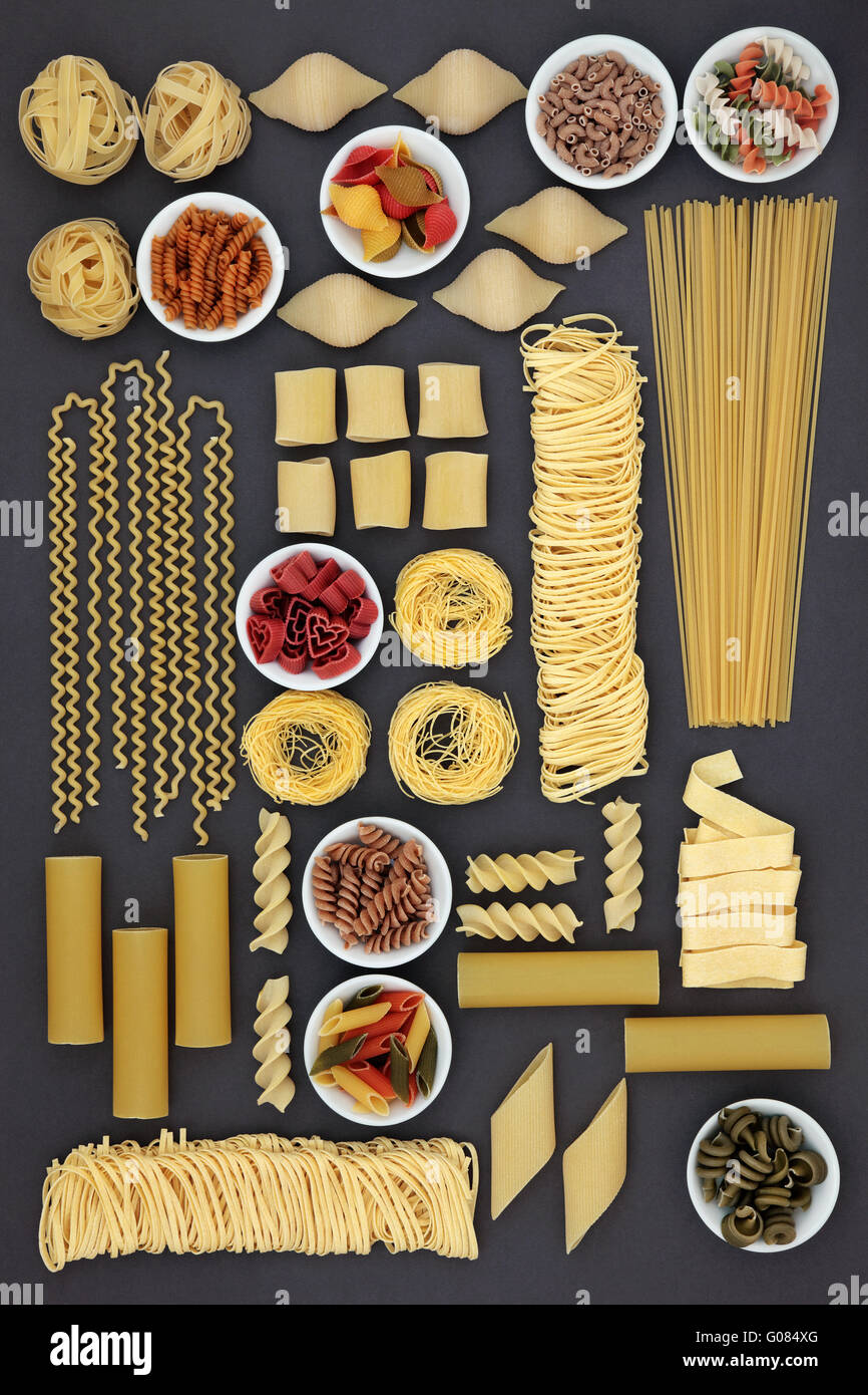 Large dried pasta spaghetti selection on grey background with coloured ...