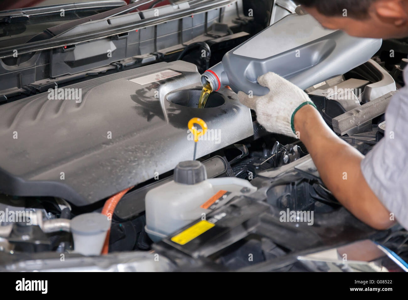 Servicing mechanic pouring new oil lubricant into the car engine Stock ...