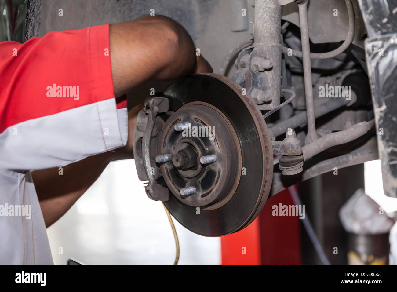 Young technician fixing brake disk in car garage Stock Photo - Alamy